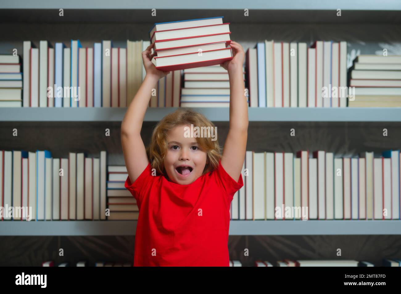 Amazed school kid hold stack of books. Excited amazed school boy ...