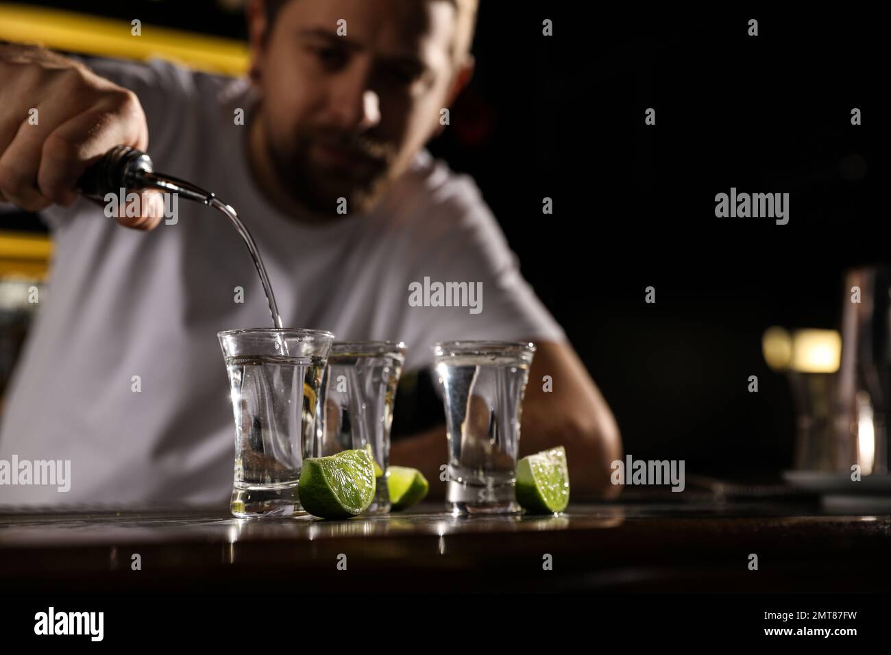 Bartender pouring Mexican Tequila into shot glass at bar counter ...