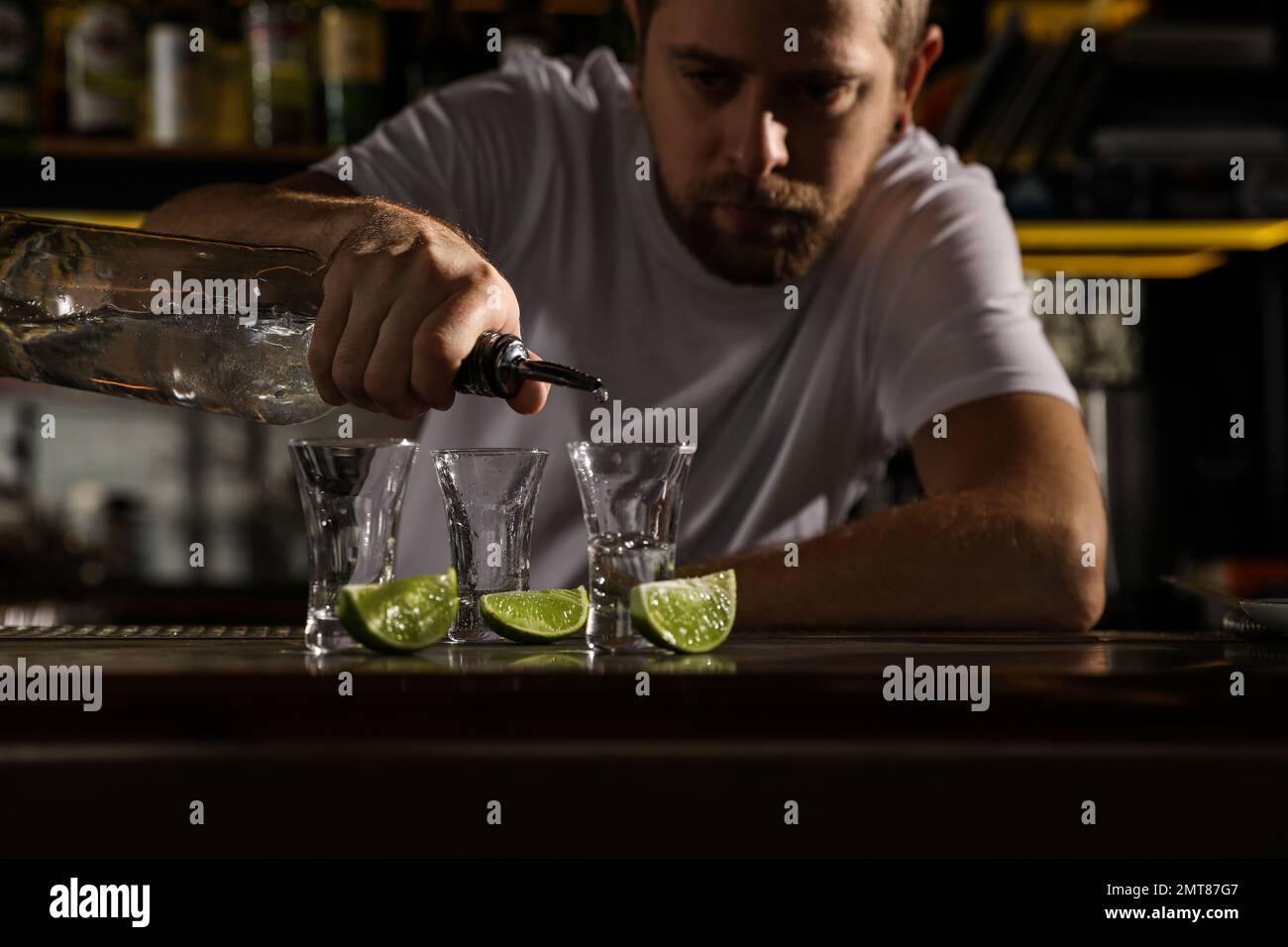 Bartender pouring Mexican Tequila into shot glass at bar counter ...