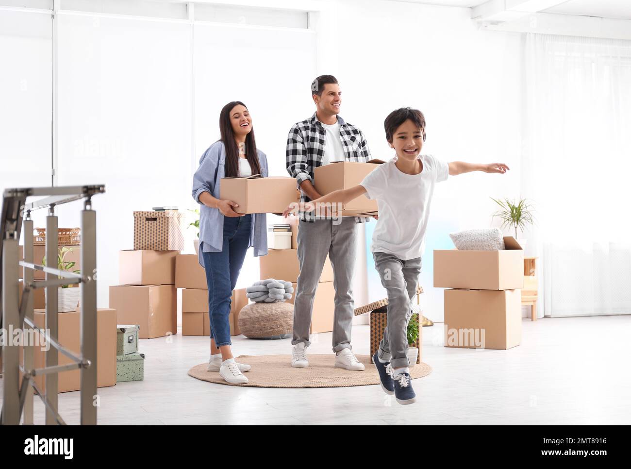Happy family in room with cardboard boxes on moving day Stock Photo - Alamy