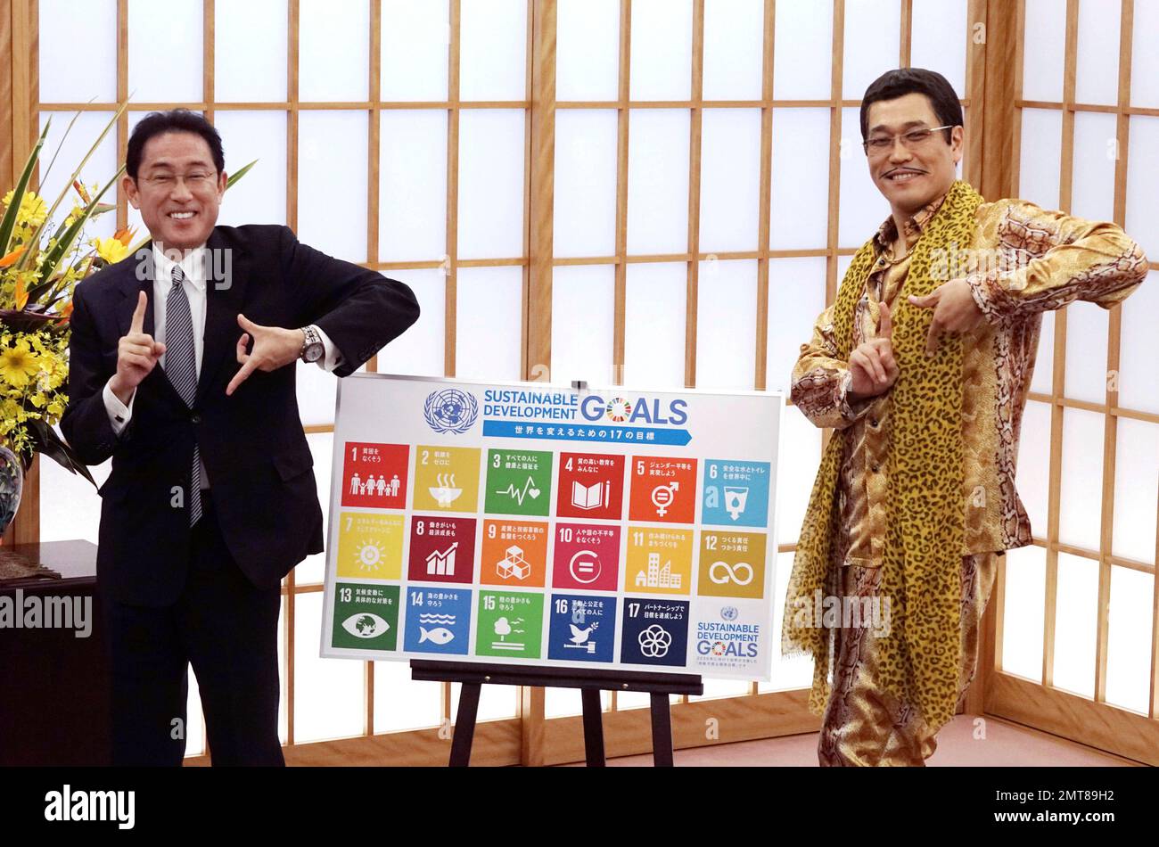 Japanese comedian Pikotaro, right, and Japan's Foreign Minister Fumio Kishida pose to raise ...