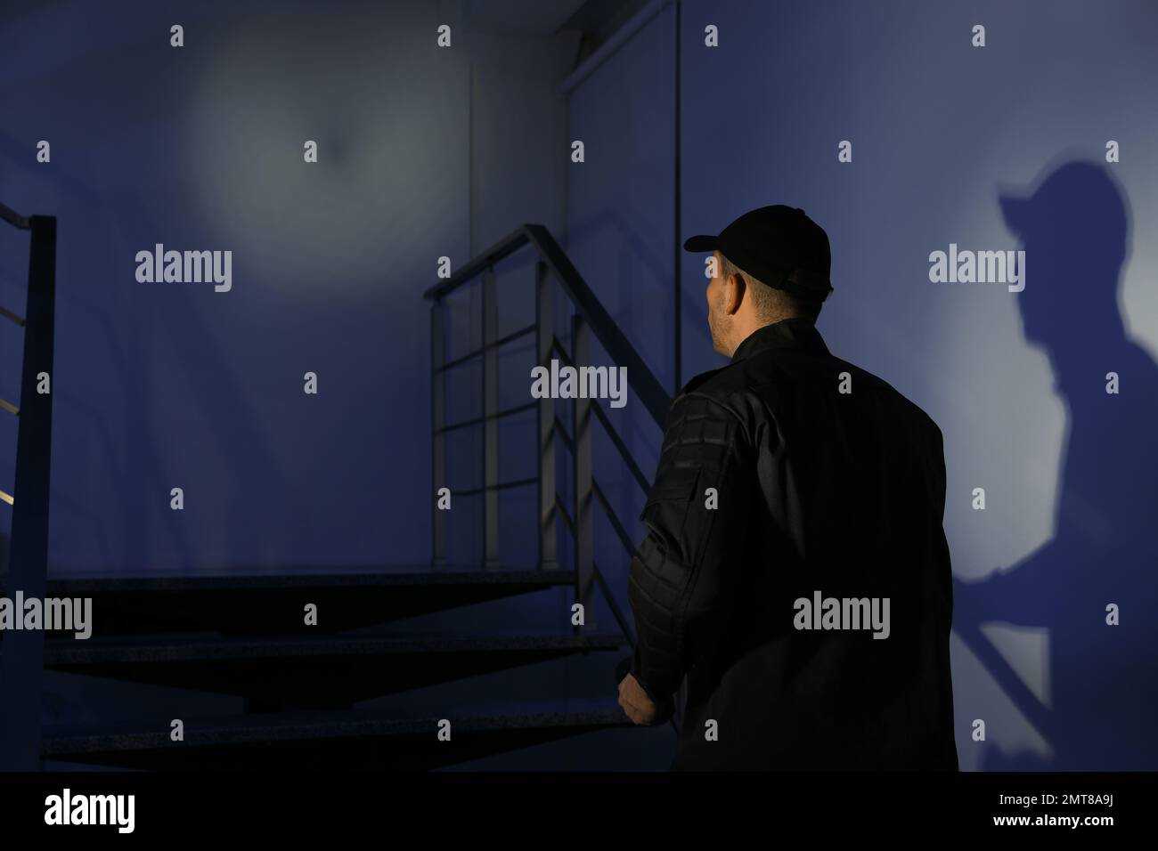 Male security guard with flashlight going up stairs in darkness Stock ...