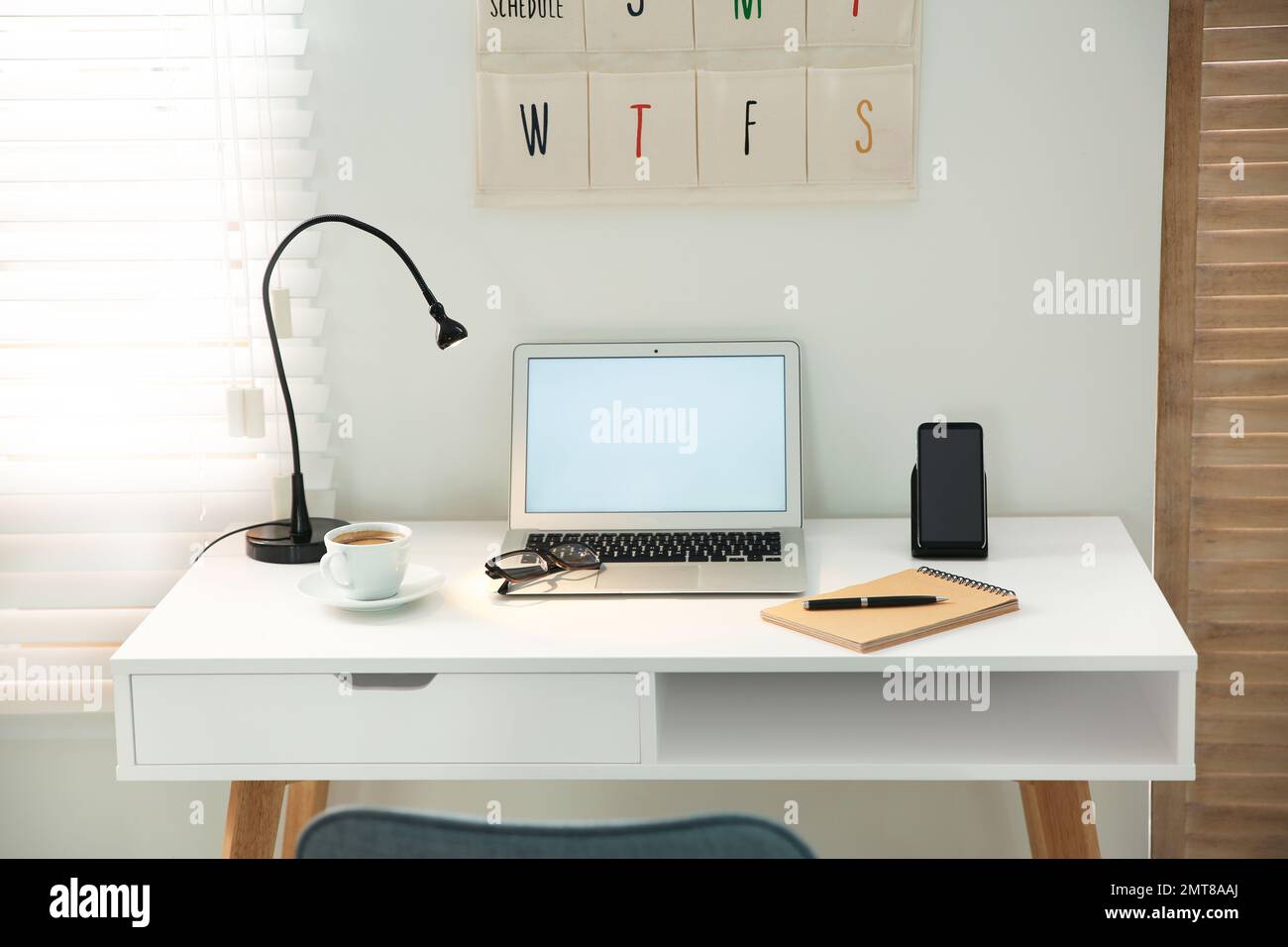 Stylish workplace with laptop, mobile phone and wireless charger Stock ...