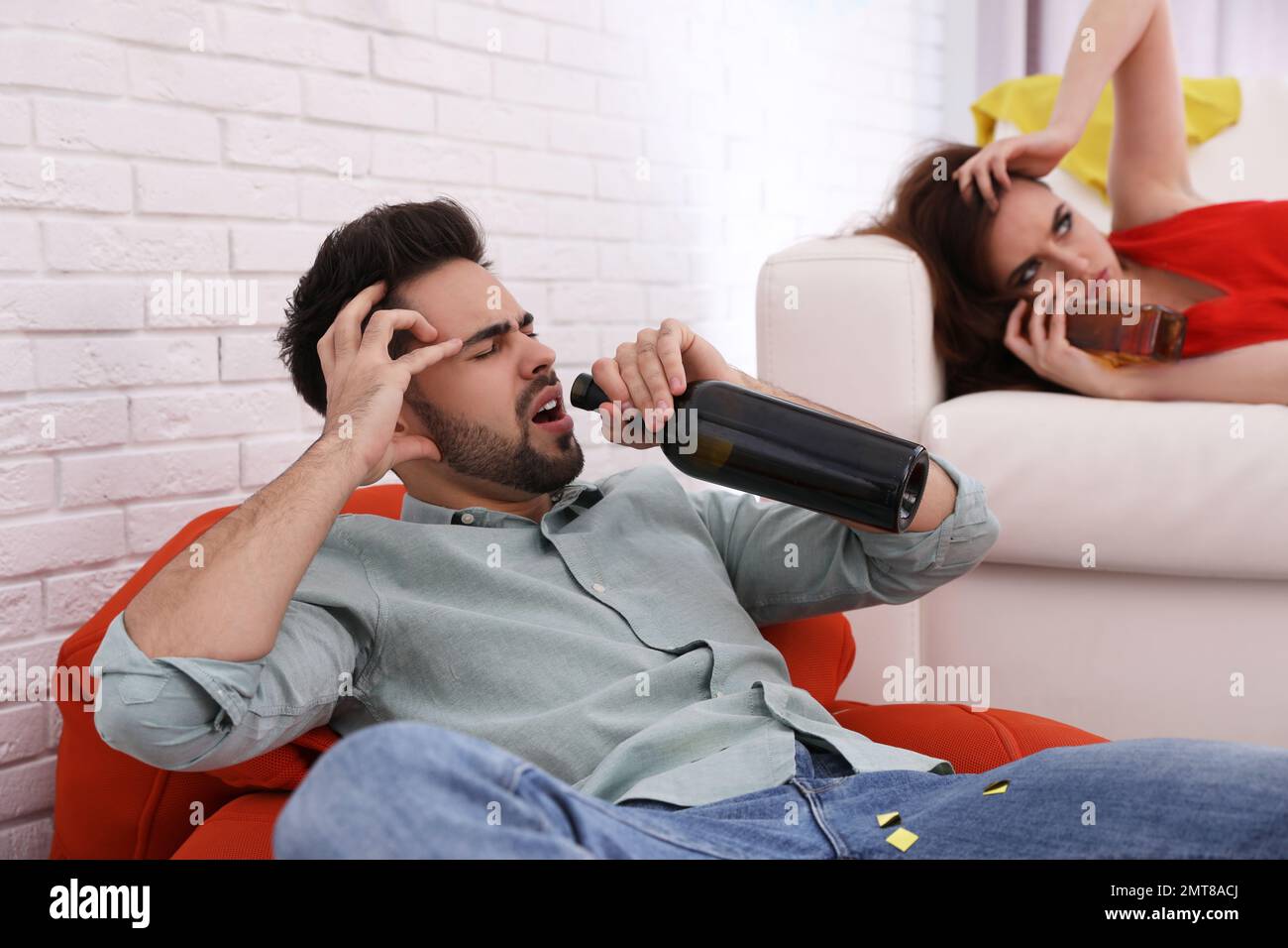 Friends suffering from hangover in messy room after party Stock Photo ...