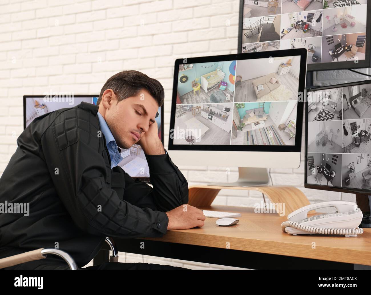 Male security guard sleeping near monitors at workplace Stock Photo - Alamy