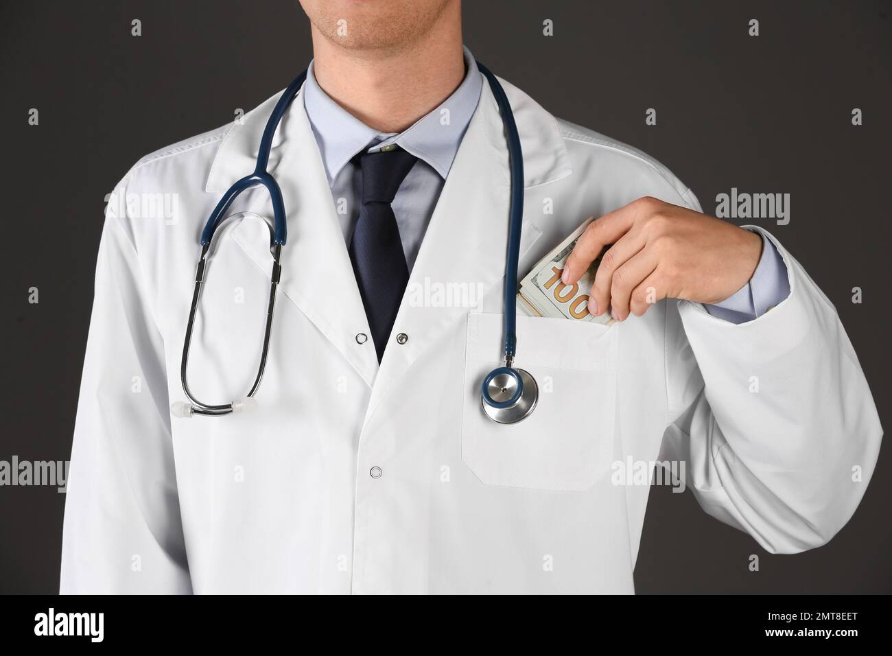 Doctor putting bribe into pocket on black background, closeup ...