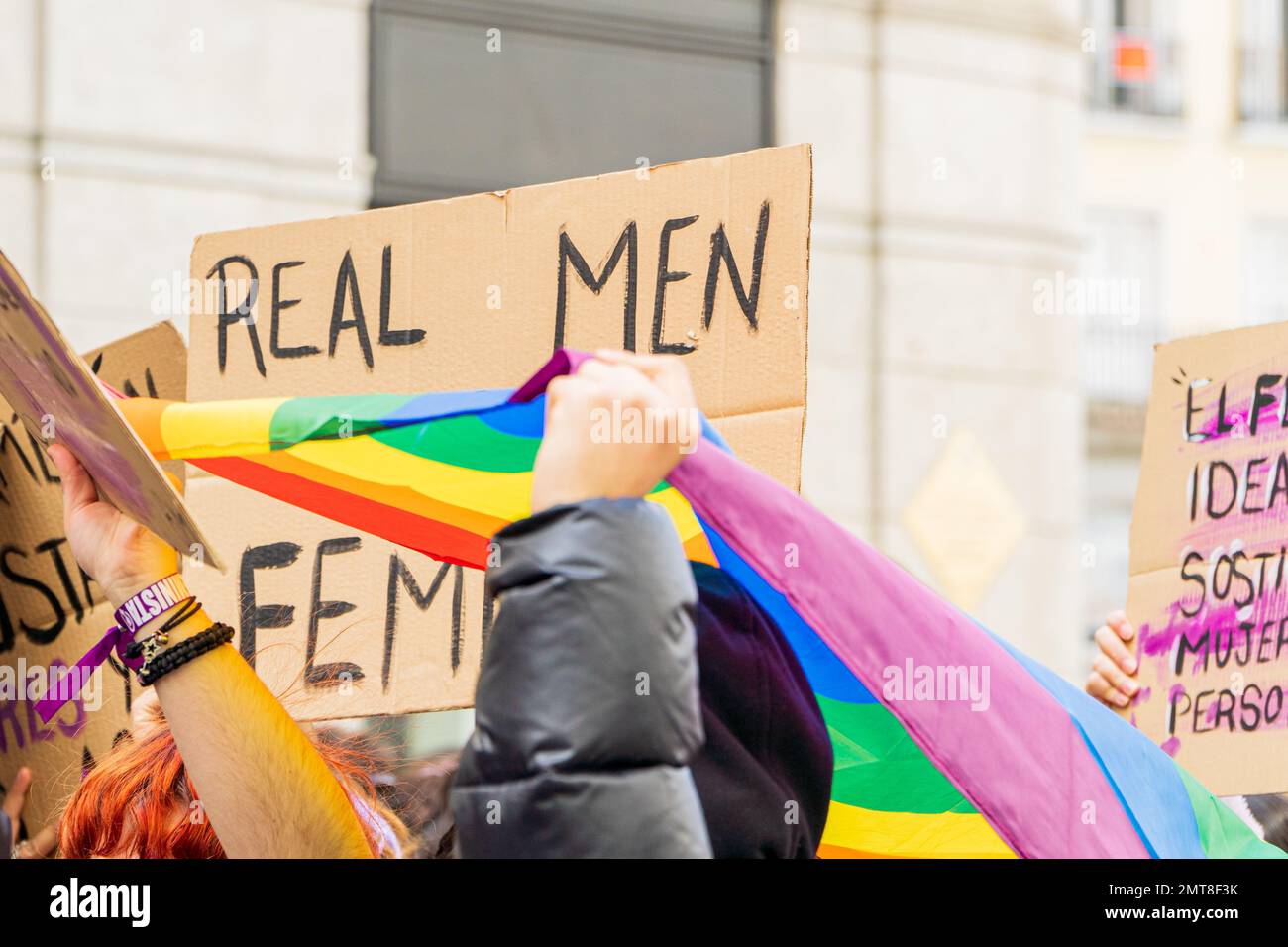 Gay young adult with lgbtq flag and supporting a feminist message ...