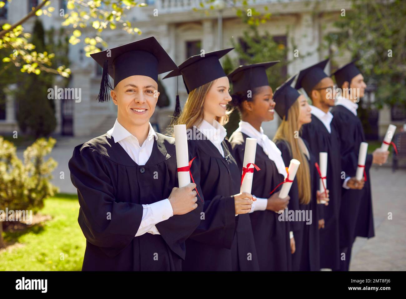 Portrait of joyful male university student with graduation ceremony ...