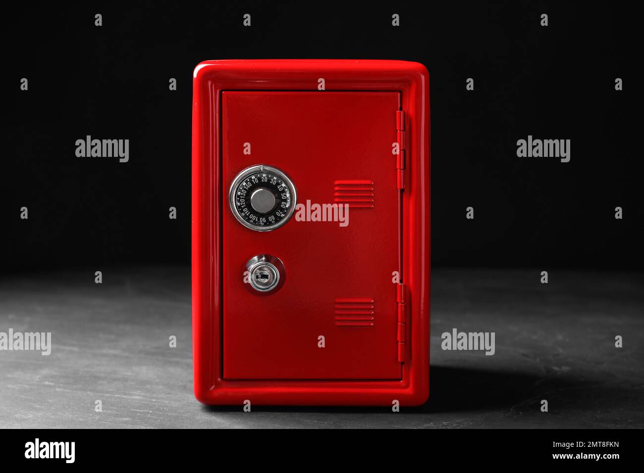 Red steel safe with mechanical combination lock against black ...
