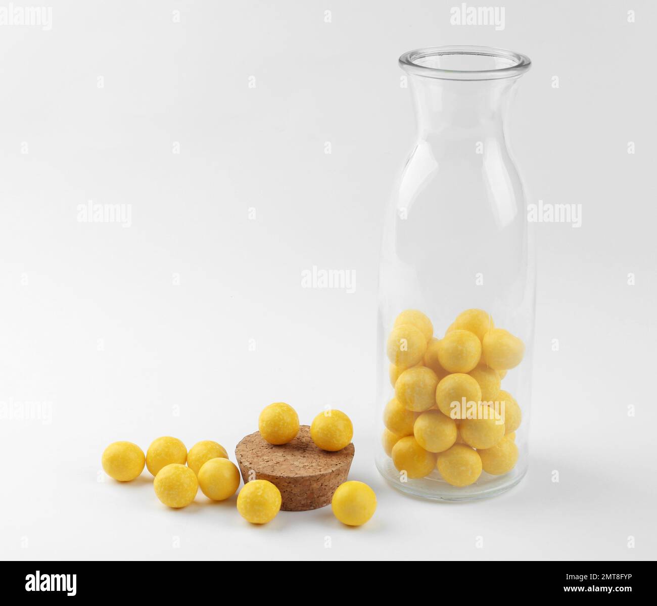 Tasty lemon drops and bottle on white background Stock Photo - Alamy