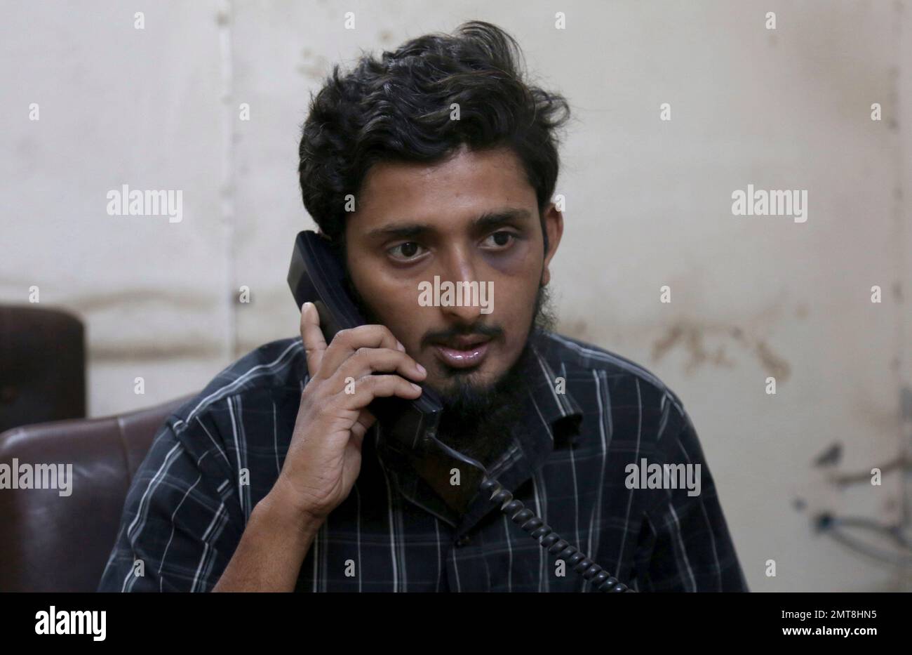 Pakistani journalist Abdullah Zafar talks on the phone at his office in Karachi, Pakistan ...