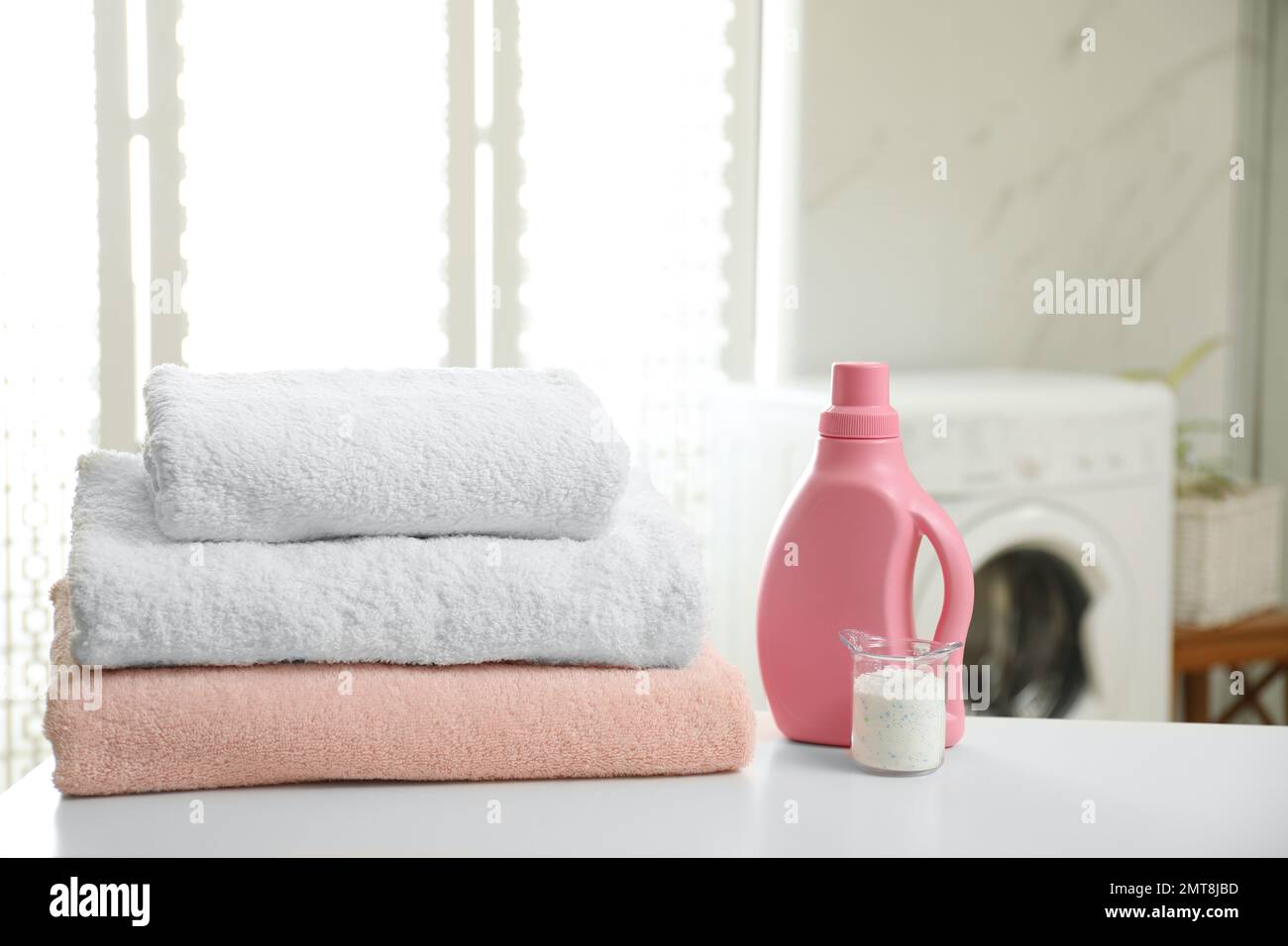 Clean towels and detergents on table in laundry room Stock Photo - Alamy