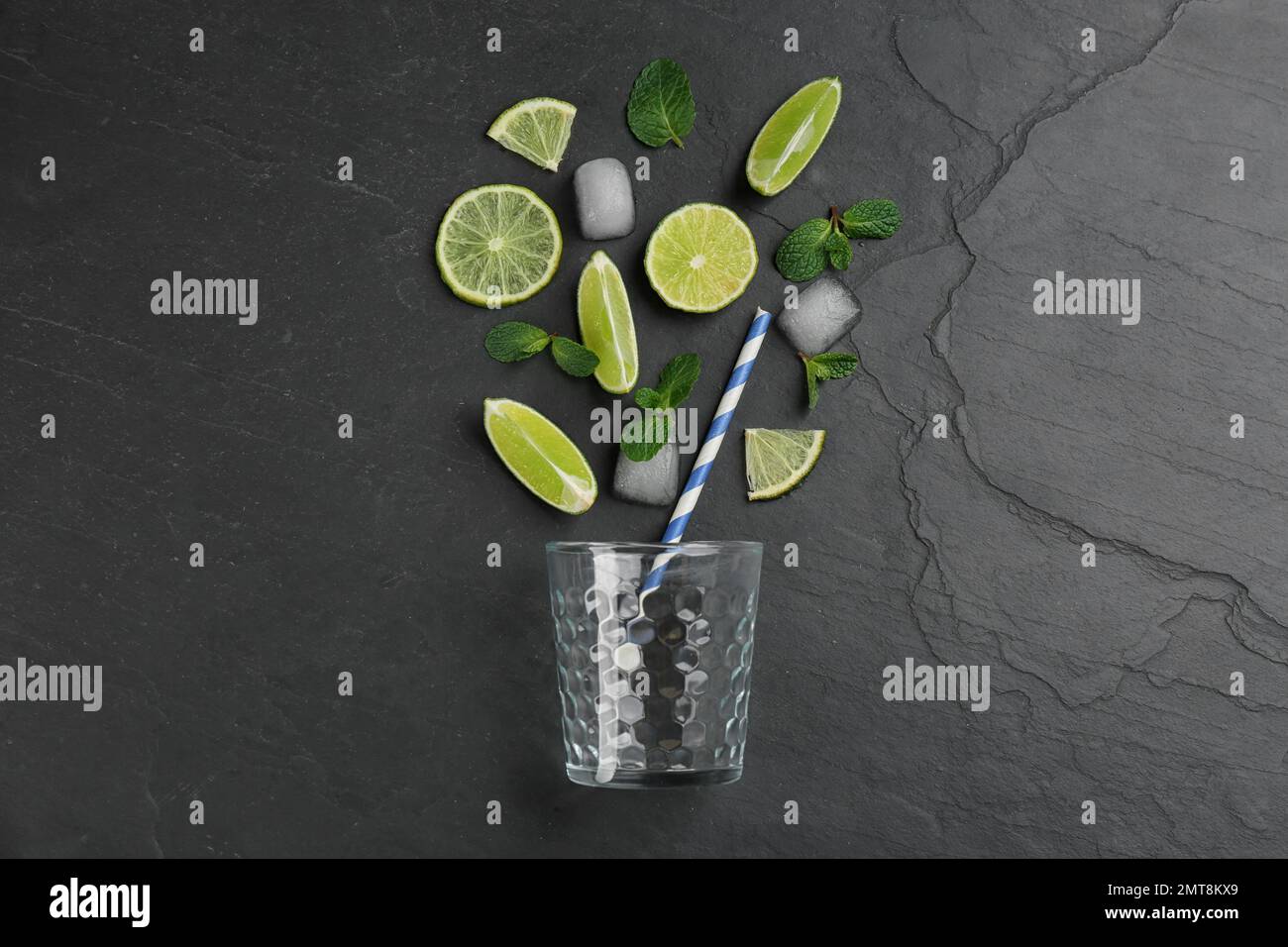 Creative lemonade layout with lemon slices, ice and mint on black table ...