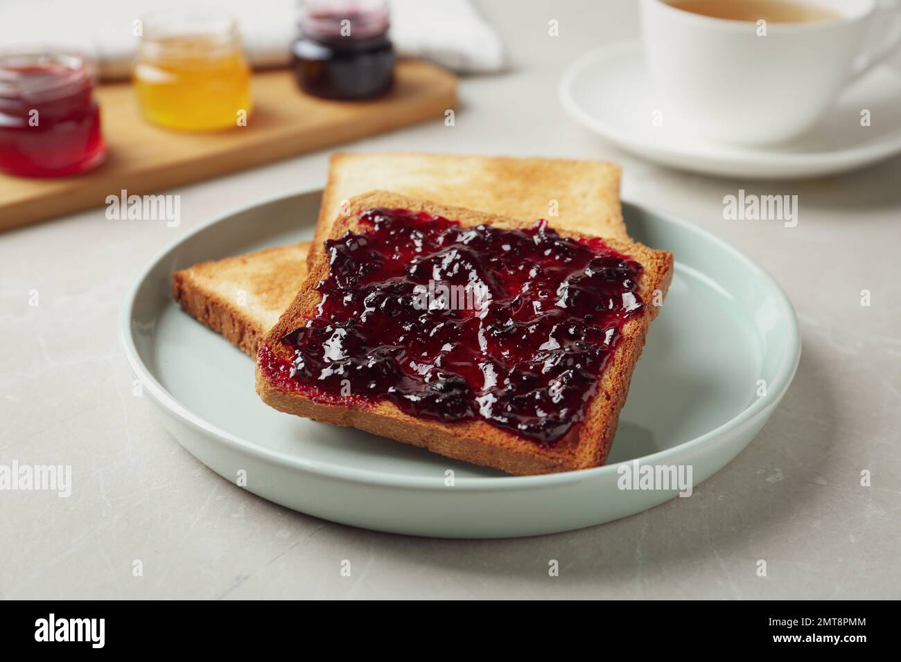 Delicious crispy toasts with jam on table Stock Photo - Alamy