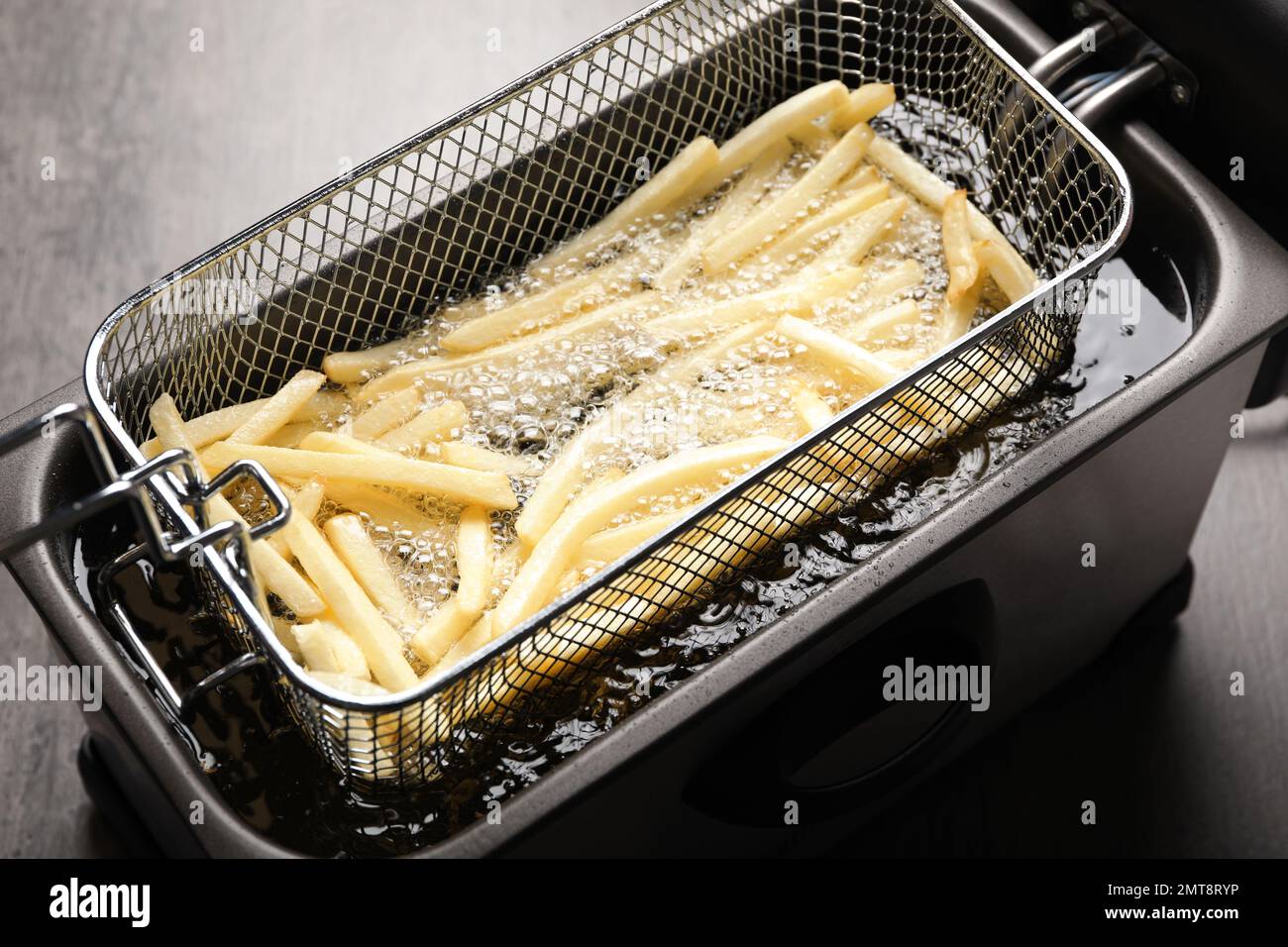 Cooking delicious french fries in hot oil Stock Photo - Alamy