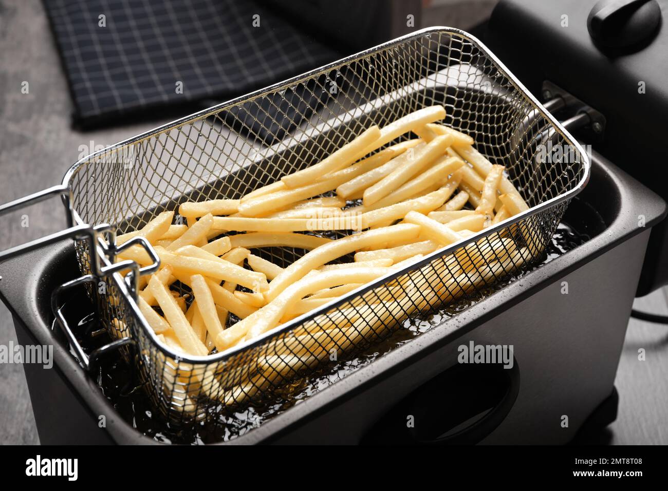 Cooking delicious french fries in hot oil Stock Photo - Alamy