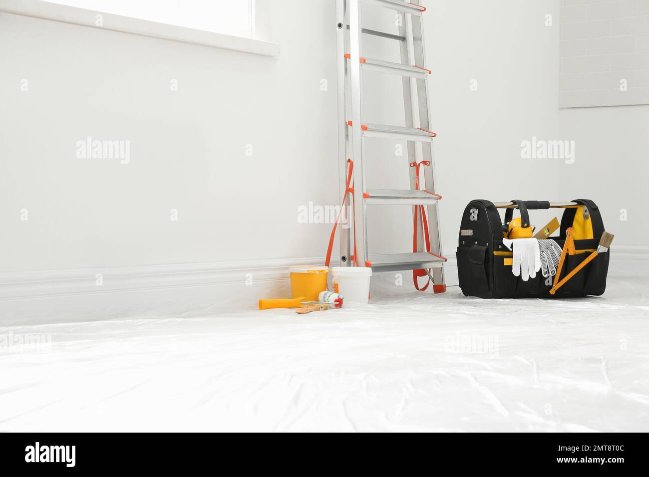 Stepladder and different tools near wall in room. Interior renovation ...