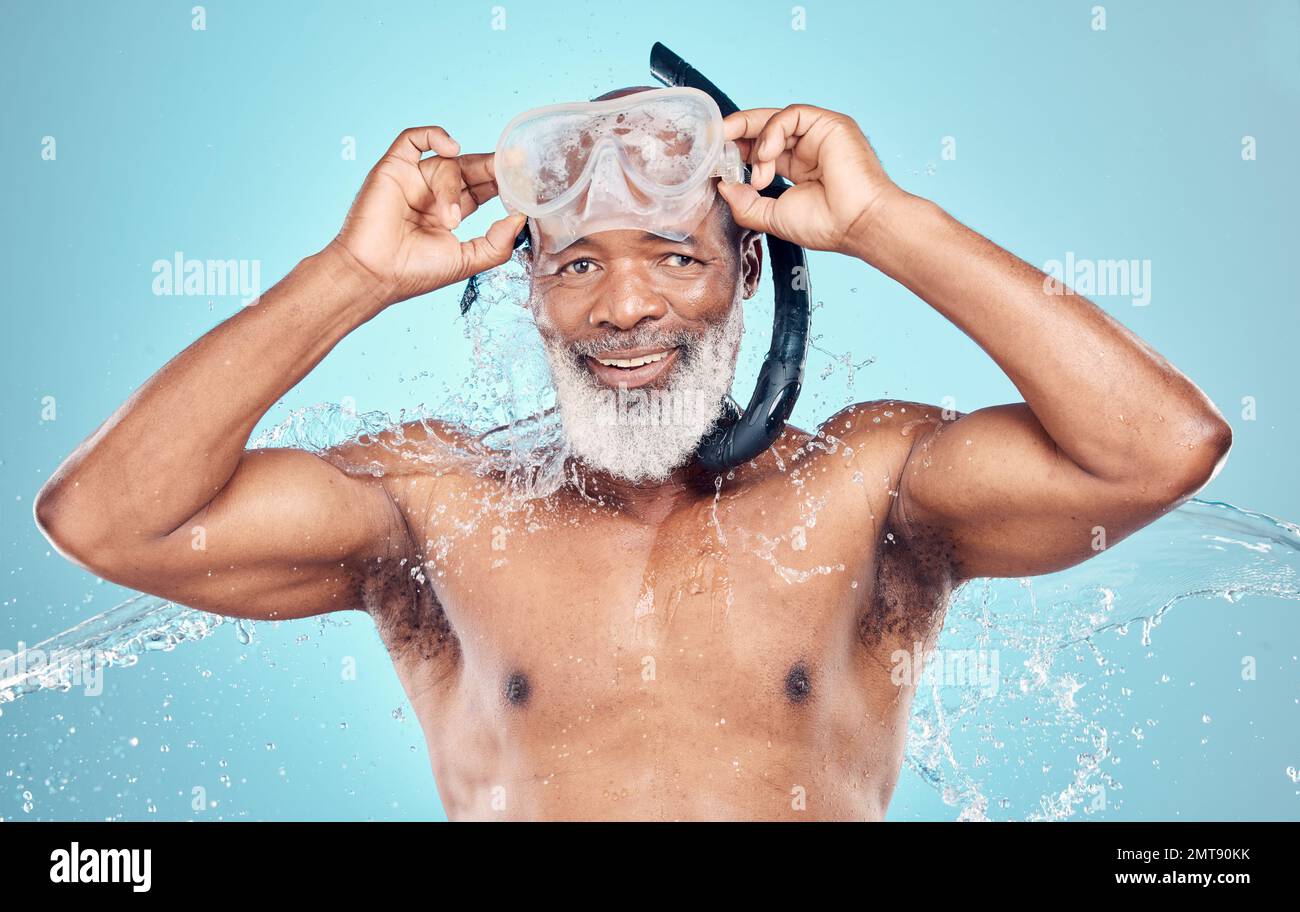Snorkel, water splash and skincare of black man in studio isolated on blue background. Wellness ...