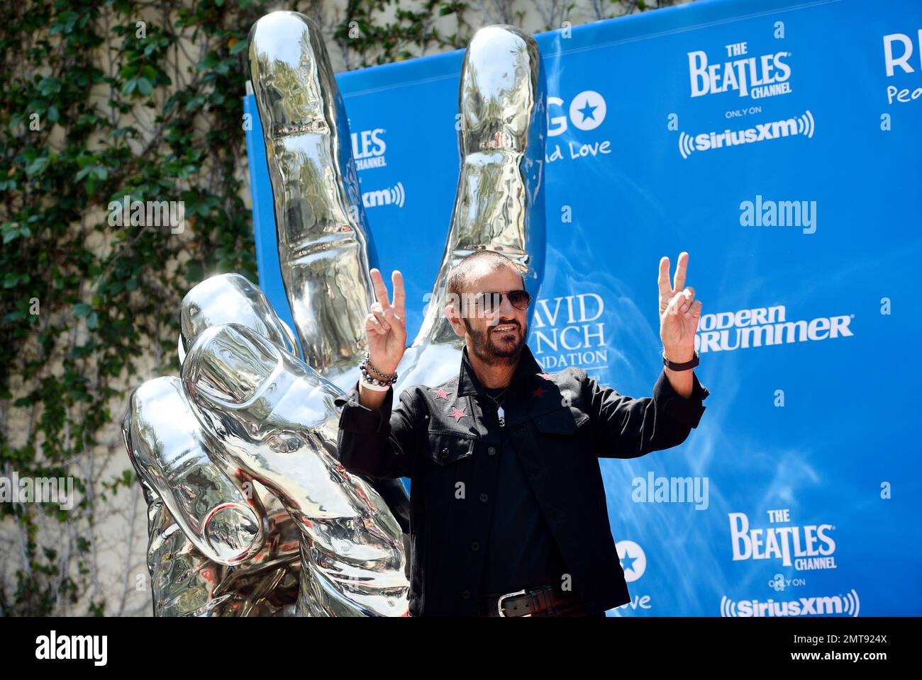 Ringo Starr mimics a peace sign statue during a 77th birthday ...