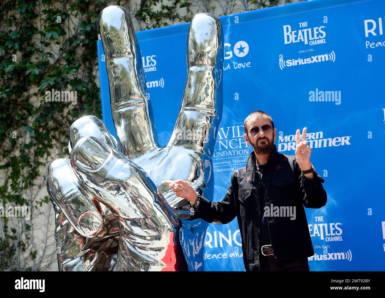 Ringo Starr mimics a peace sign statue during a 77th birthday ...