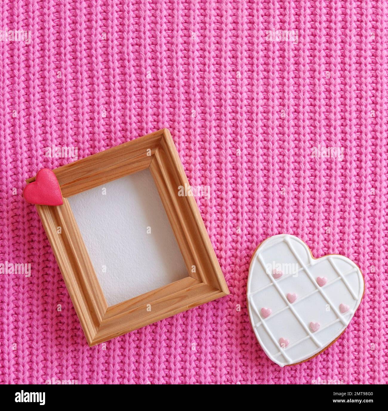 Gingerbread valentine on a knitted pink background. View from above ...