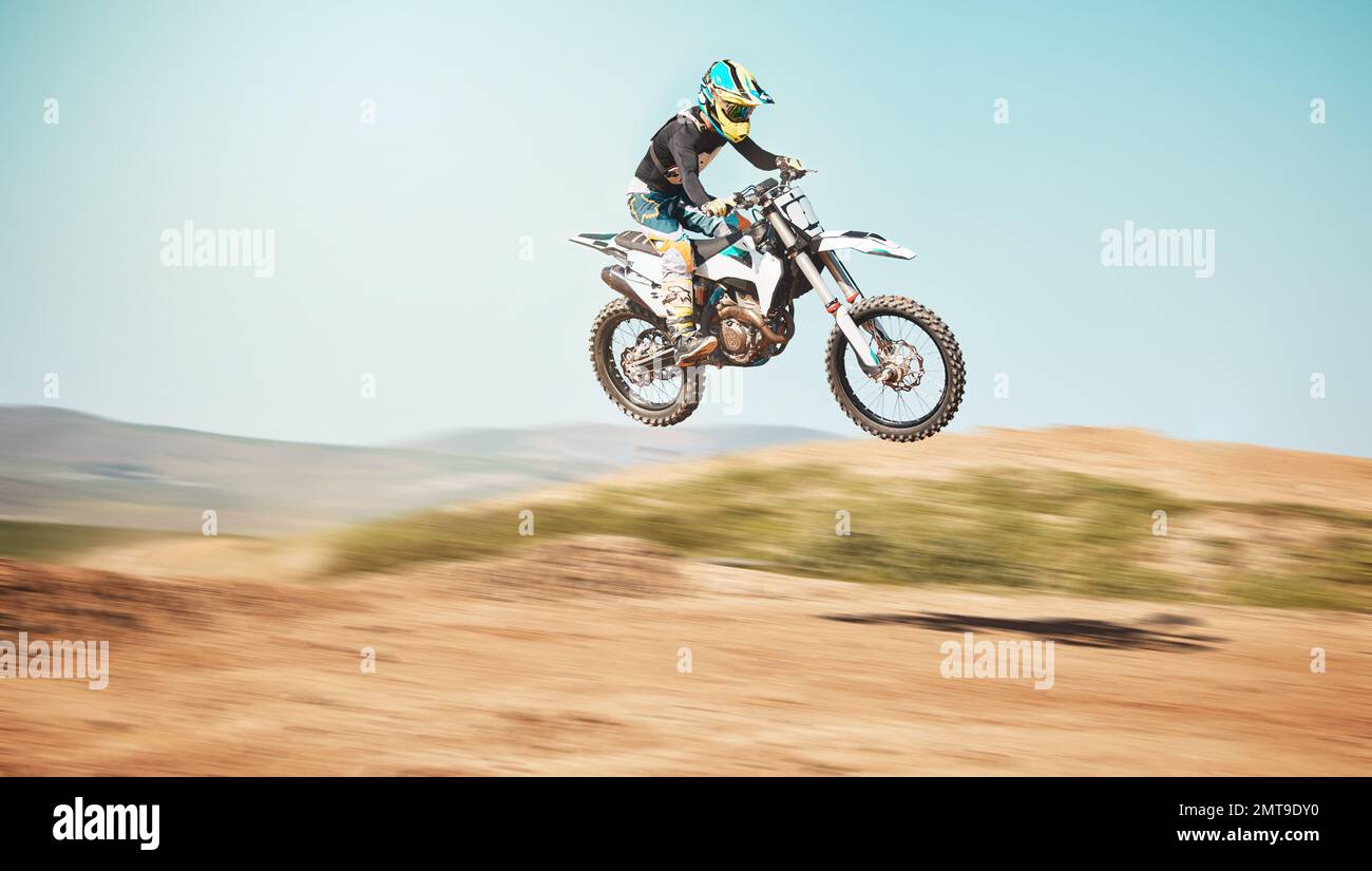 Motorcycle, offroad driving and air jump in desert, blue sky and ...
