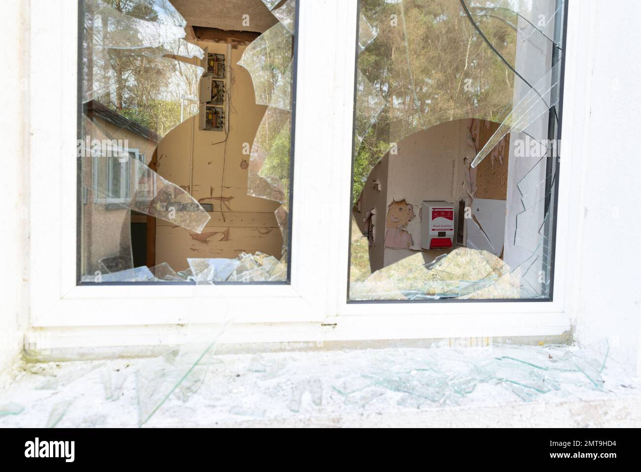 Room interior viewed through broken window in abandoned derelict ...