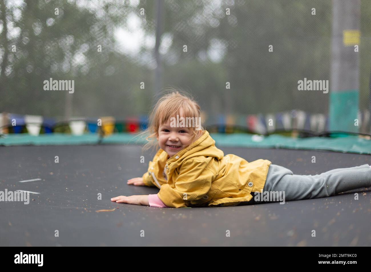 Little girl jumping on trampoline and going down the slide Stock Photo ...