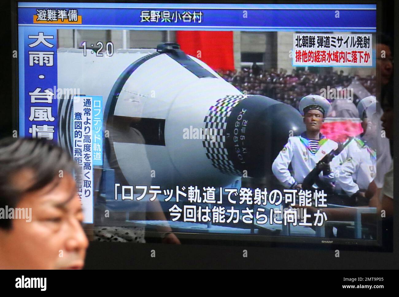 A man walks past a public TV screen broadcasting news of North Korea's ballistic missile which ...