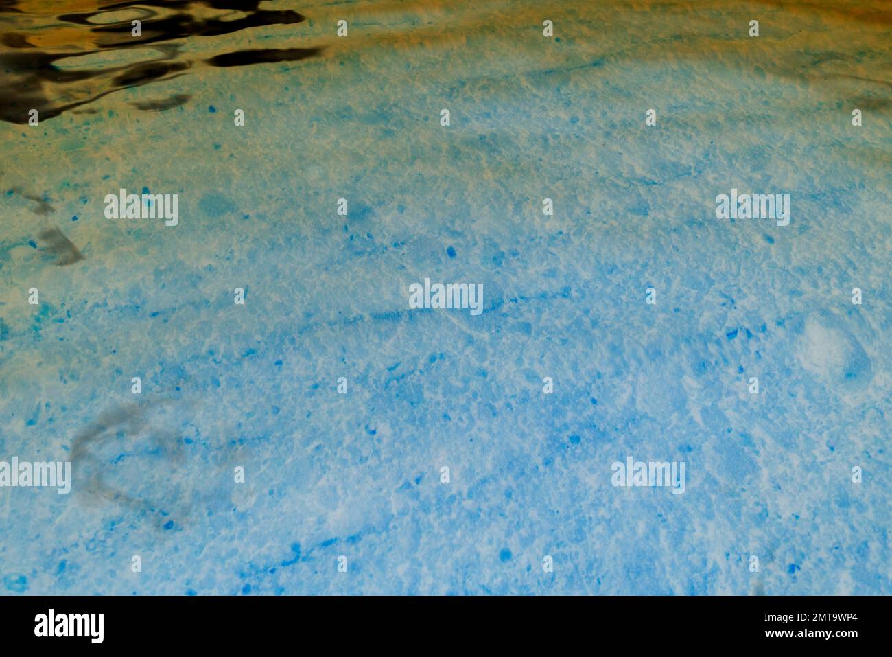 Abstract photo of blue neon water surface with sandy bottom and waves ...