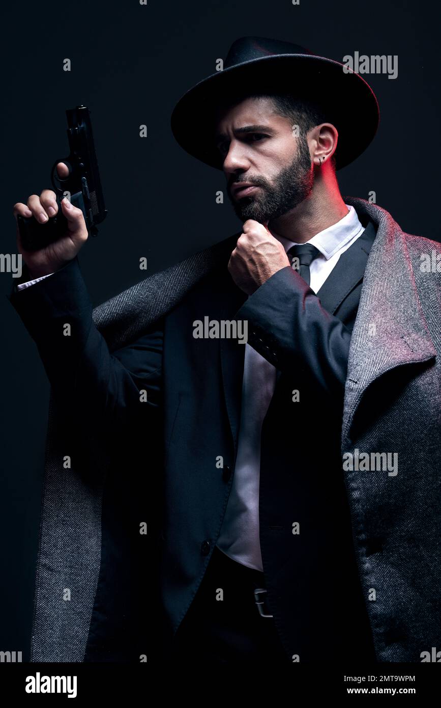 Gangster, leadership or holding gun on studio background in dark secret ...