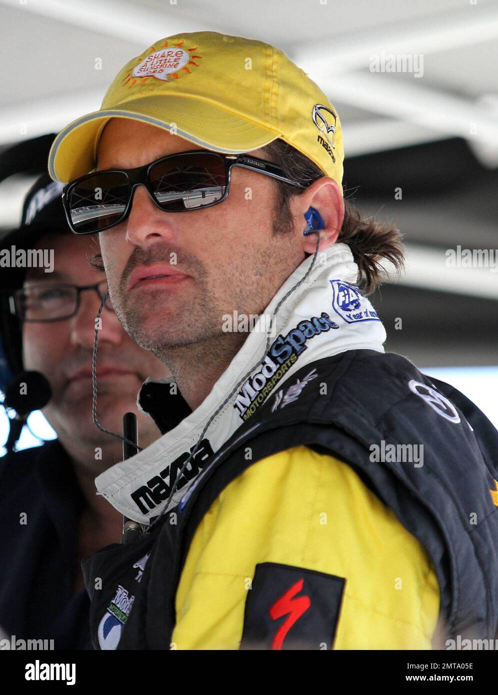 Patrick Dempsey stretches in his racing jumpsuit and helmet and gets ...