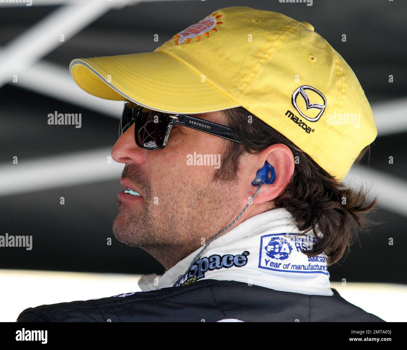 Patrick Dempsey stretches in his racing jumpsuit and helmet and gets ...