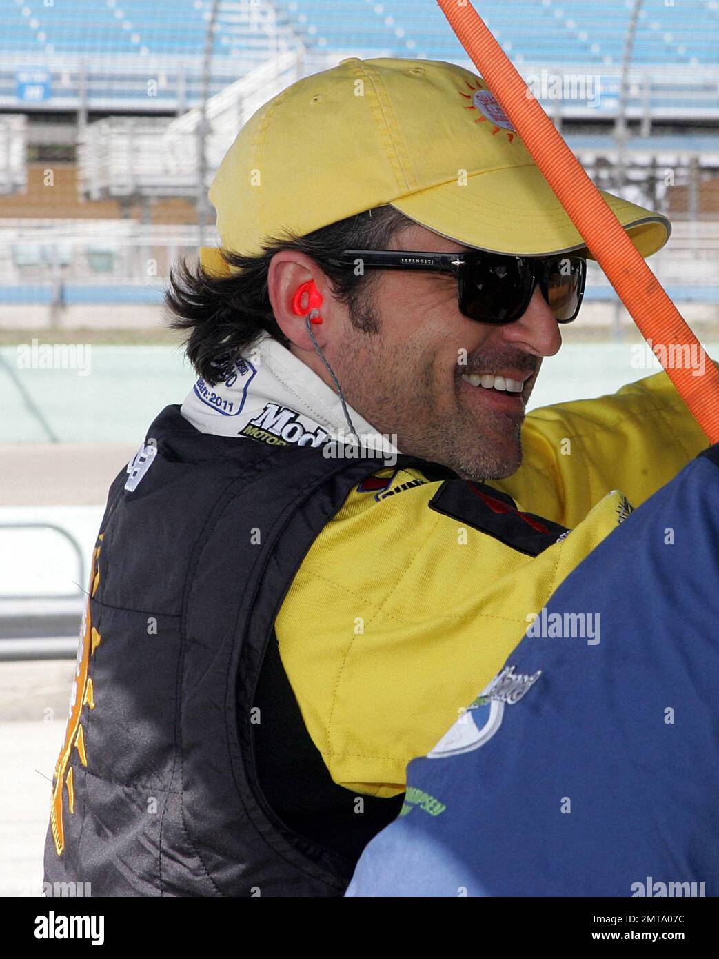 Patrick Dempsey stretches in his racing jumpsuit and helmet and gets ...