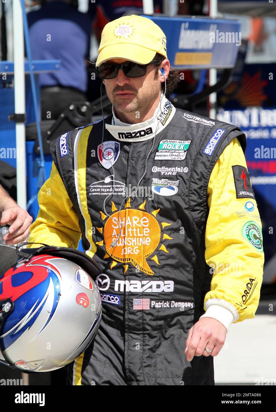 Patrick Dempsey stretches in his racing jumpsuit and helmet and gets ...