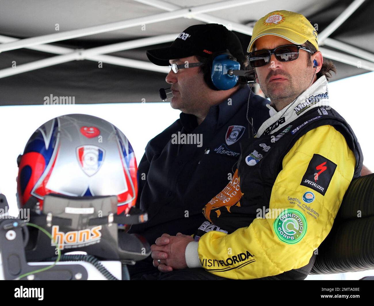 Patrick Dempsey stretches in his racing jumpsuit and helmet and gets ...