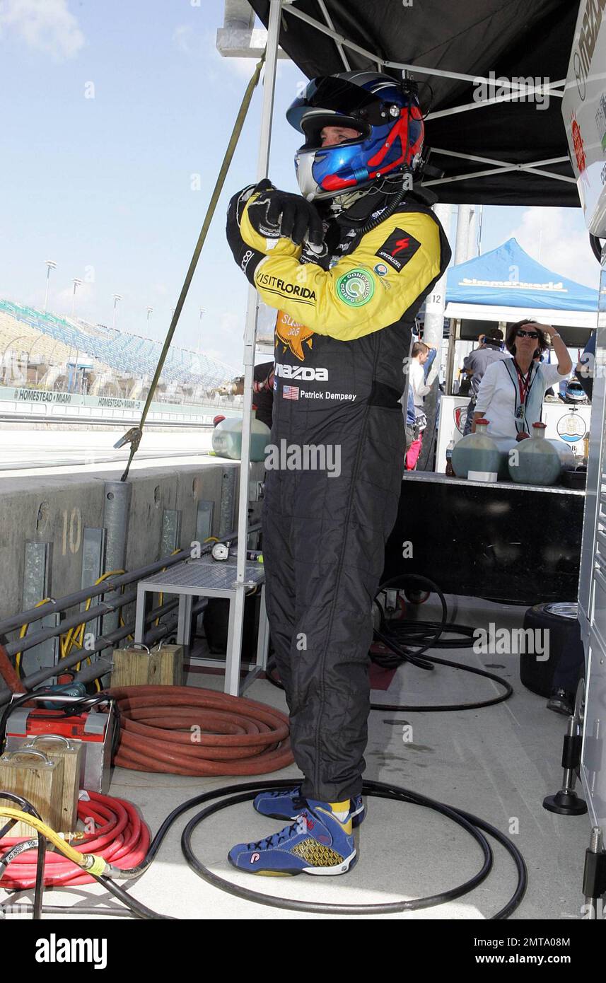 Patrick Dempsey stretches in his racing jumpsuit and helmet and gets ...
