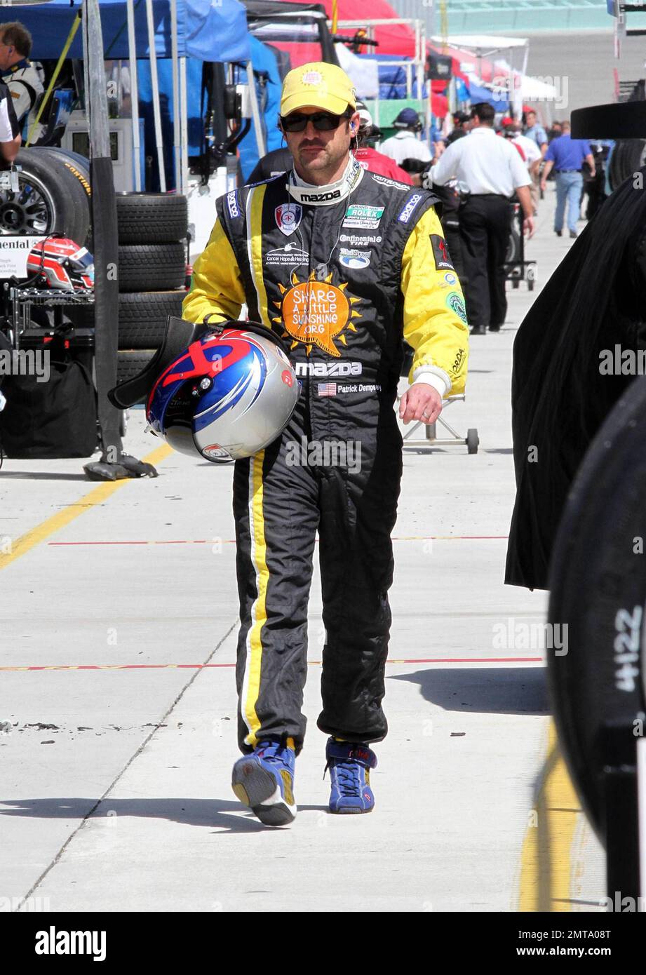 Patrick Dempsey stretches in his racing jumpsuit and helmet and gets ...