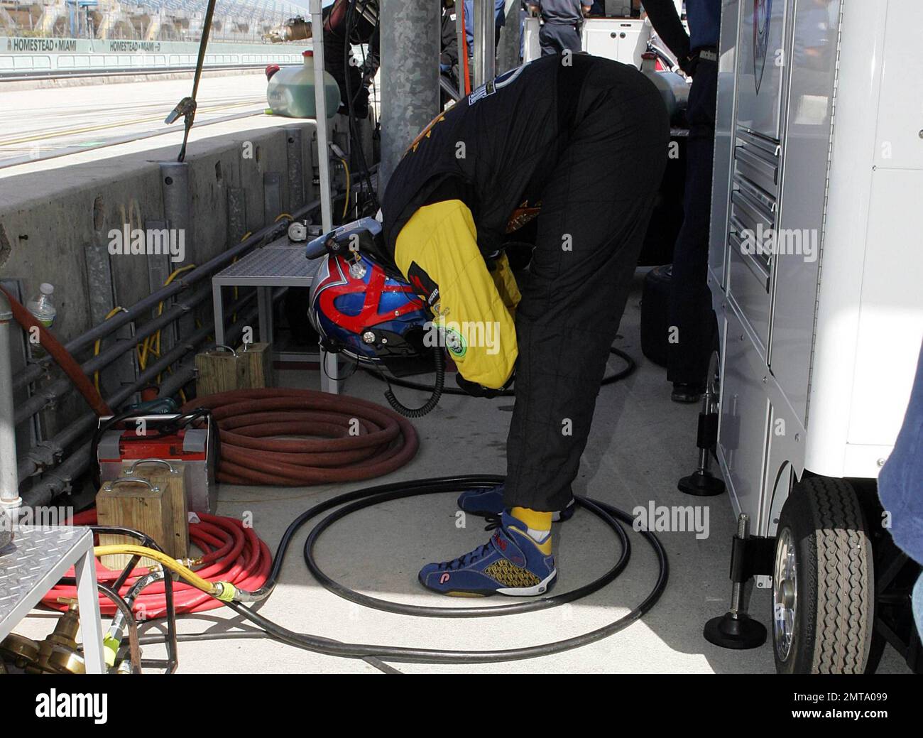 Patrick Dempsey stretches in his racing jumpsuit and helmet and gets ...