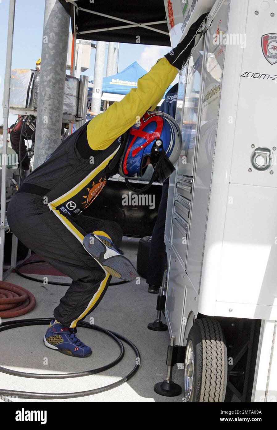 Patrick Dempsey stretches in his racing jumpsuit and helmet and gets ...