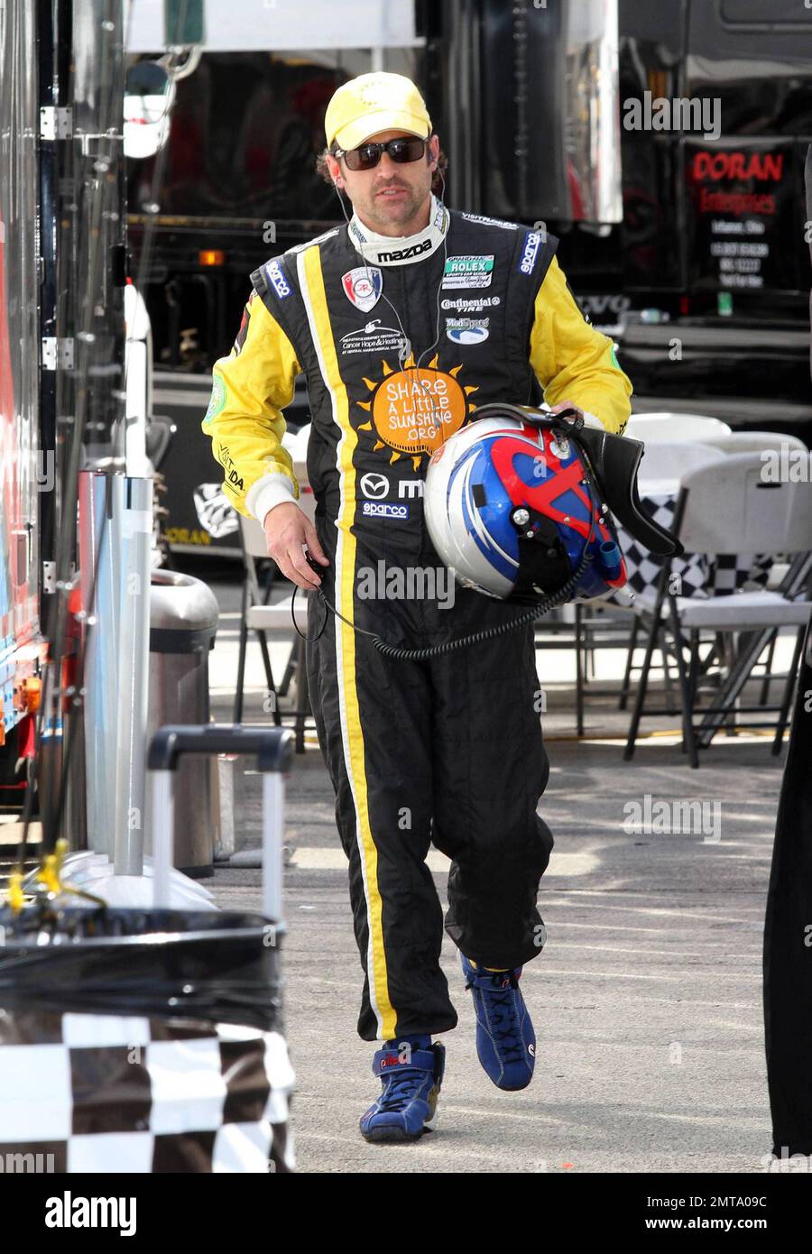 Patrick Dempsey stretches in his racing jumpsuit and helmet and gets ...