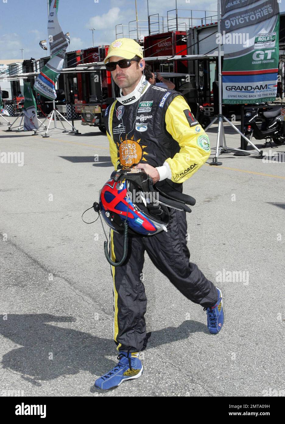 Patrick Dempsey stretches in his racing jumpsuit and helmet and gets ...
