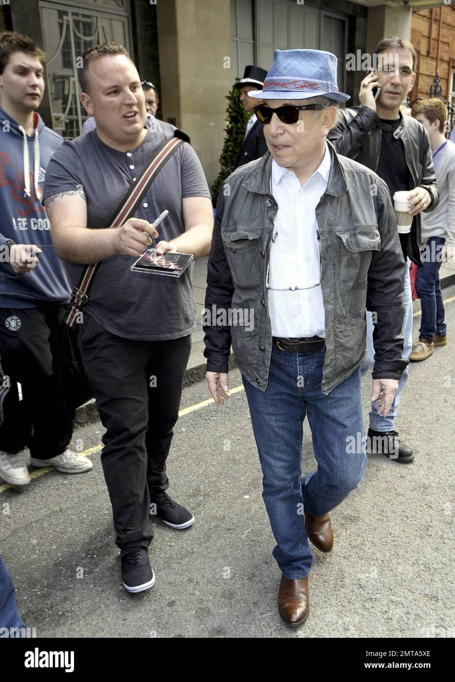 Singer Paul Simon passes by autograph seekers who waited outside for ...