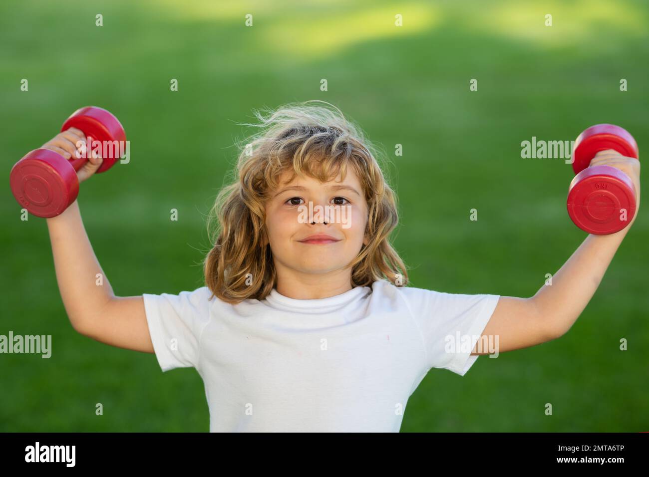 Summer sport. Sport activities at leisure with children. Blonde boy holding dumbbells. Sports ...
