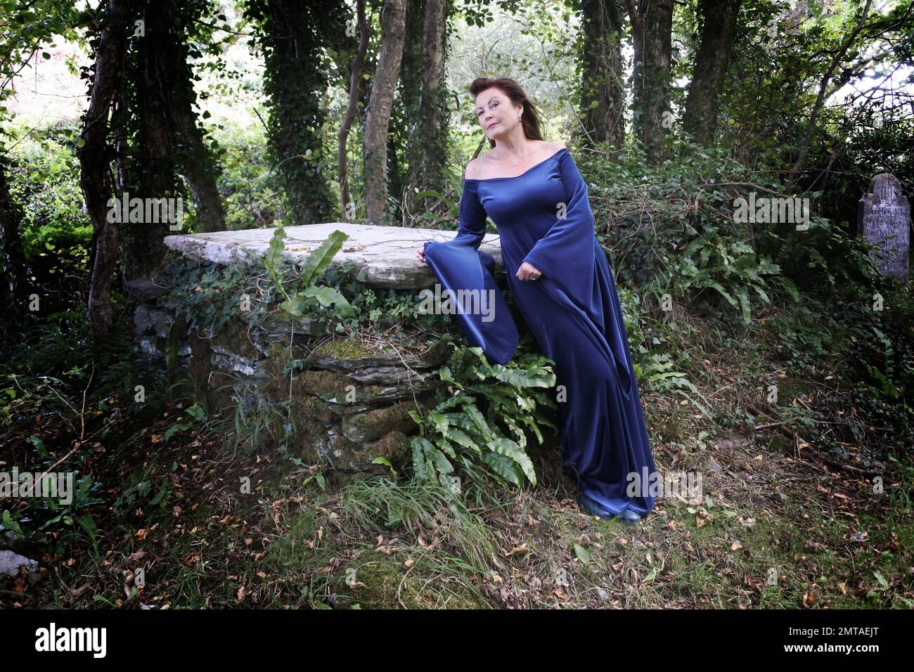 Beautiful gothic witch standing in an ancient cemetery - John Gollop ...