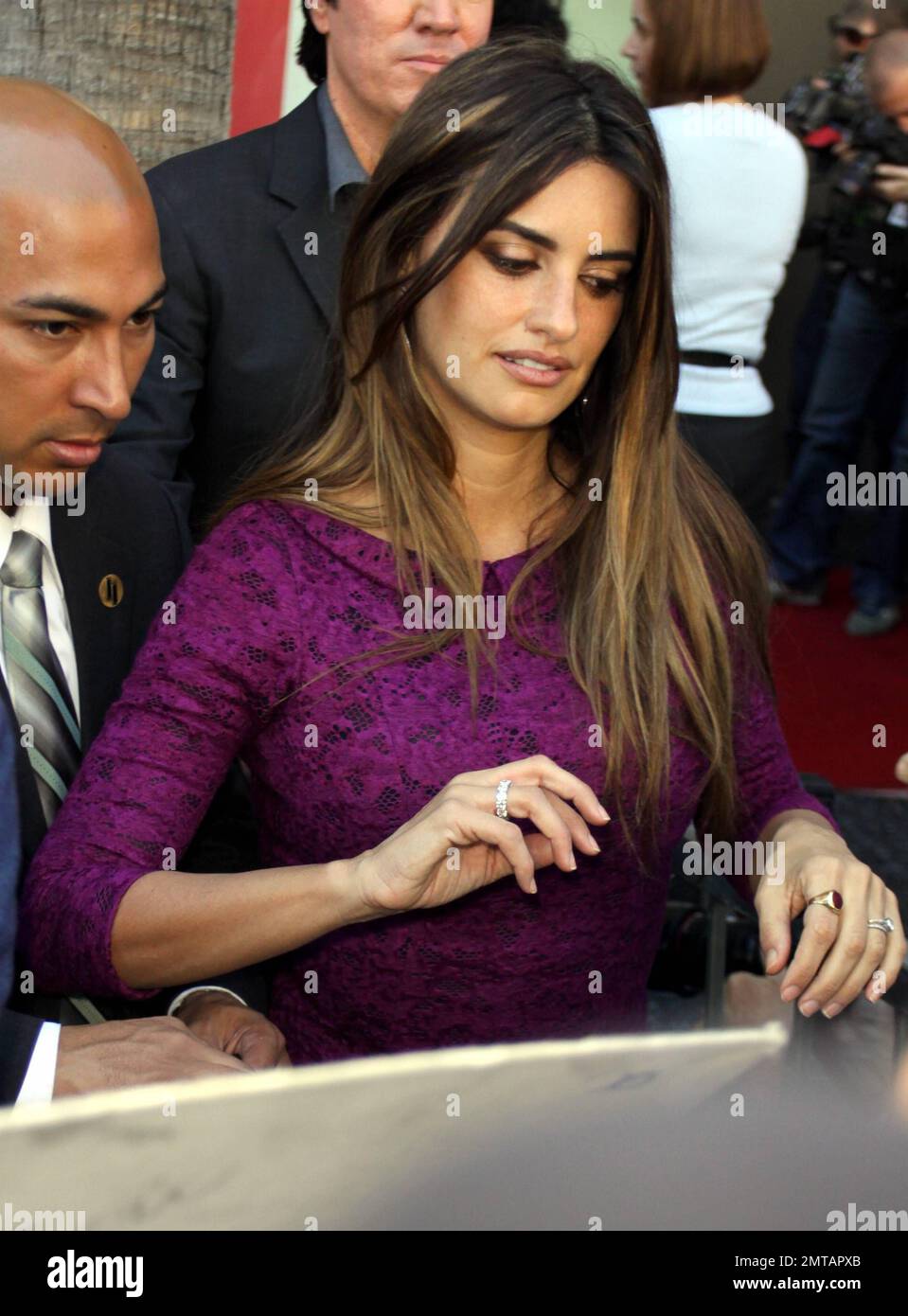 Actress Penelope Cruz wears a form-fitting purple dress showing off her ...