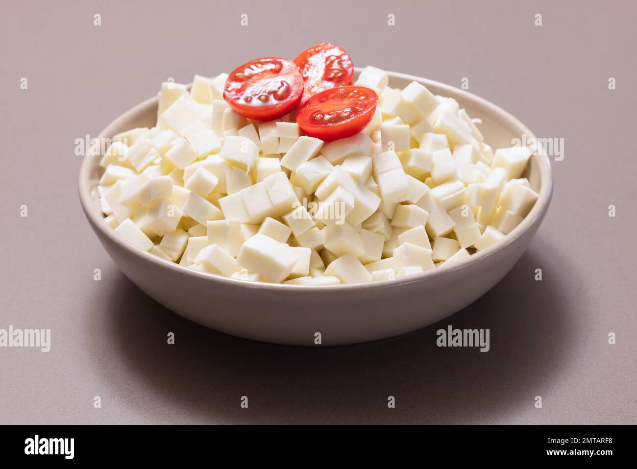 Plate with Italian cow mozzarella cheese cut into cubes for pizza ...