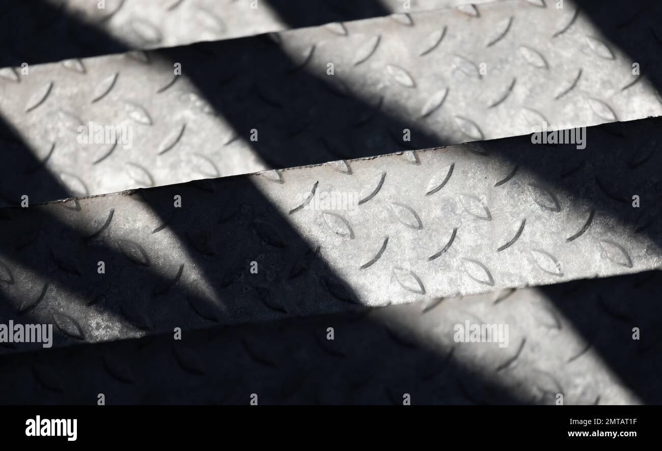 Gray steel industrial stairs with diamond plate pattern and shadows ...