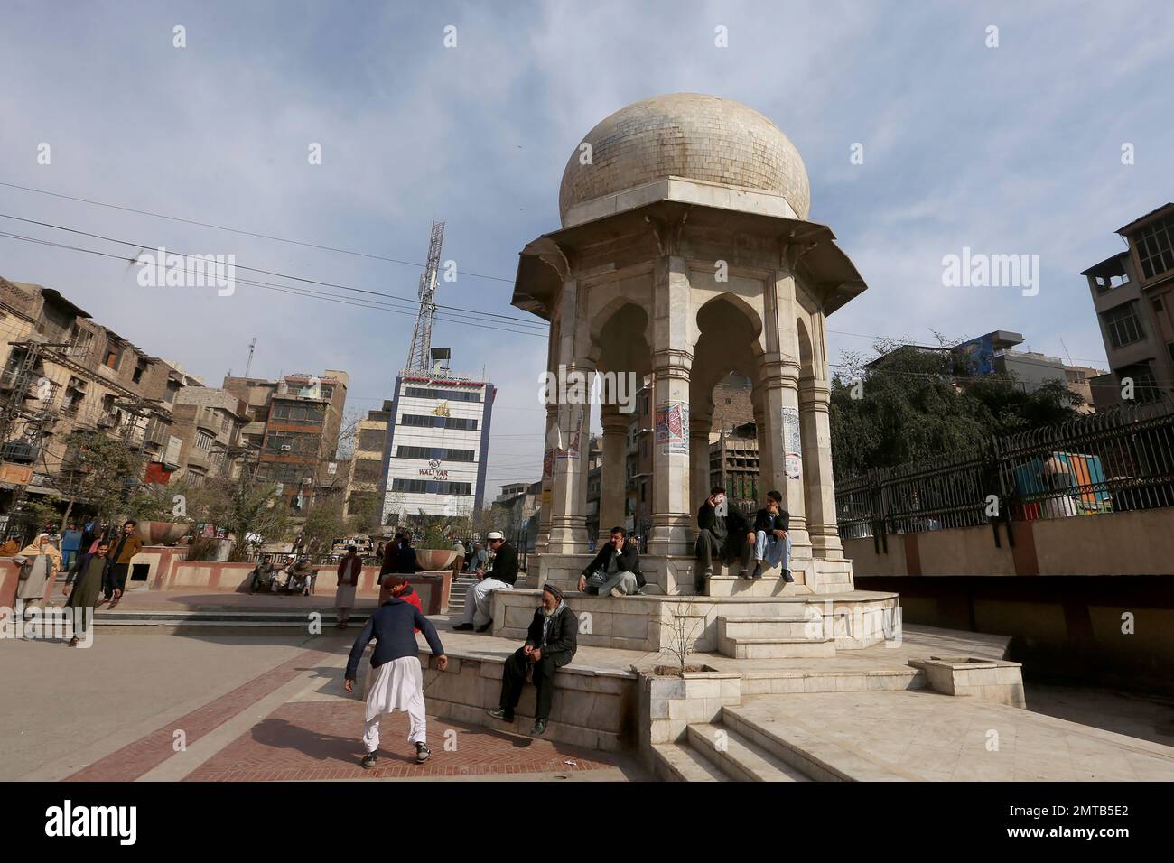 People sit near a monument called 'Chowk Yadgar', in the old area of ...