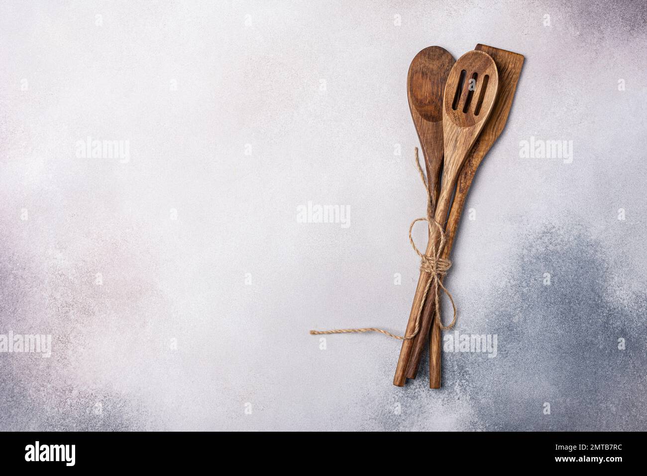 Utensils cutlery. Top view of rustic wooden scapula and spoons on grey ...